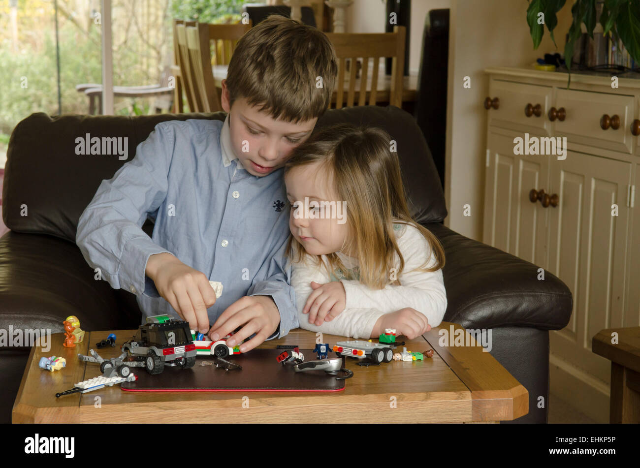 boy, eight years old, with sister, two years old, playing with Lego ...