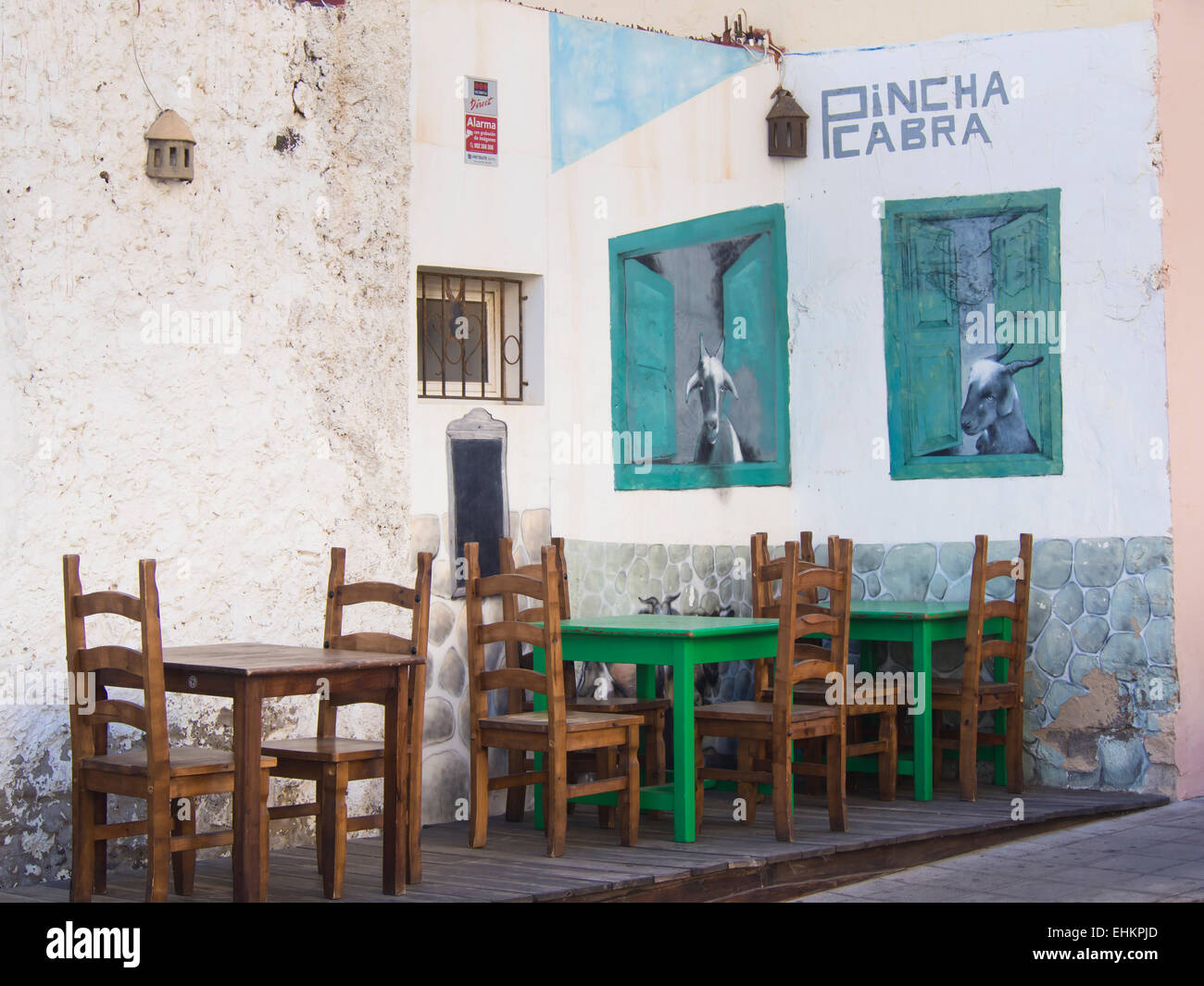 Outdoors tables and colourful humorous murals in the bar Pincha Cabra ...