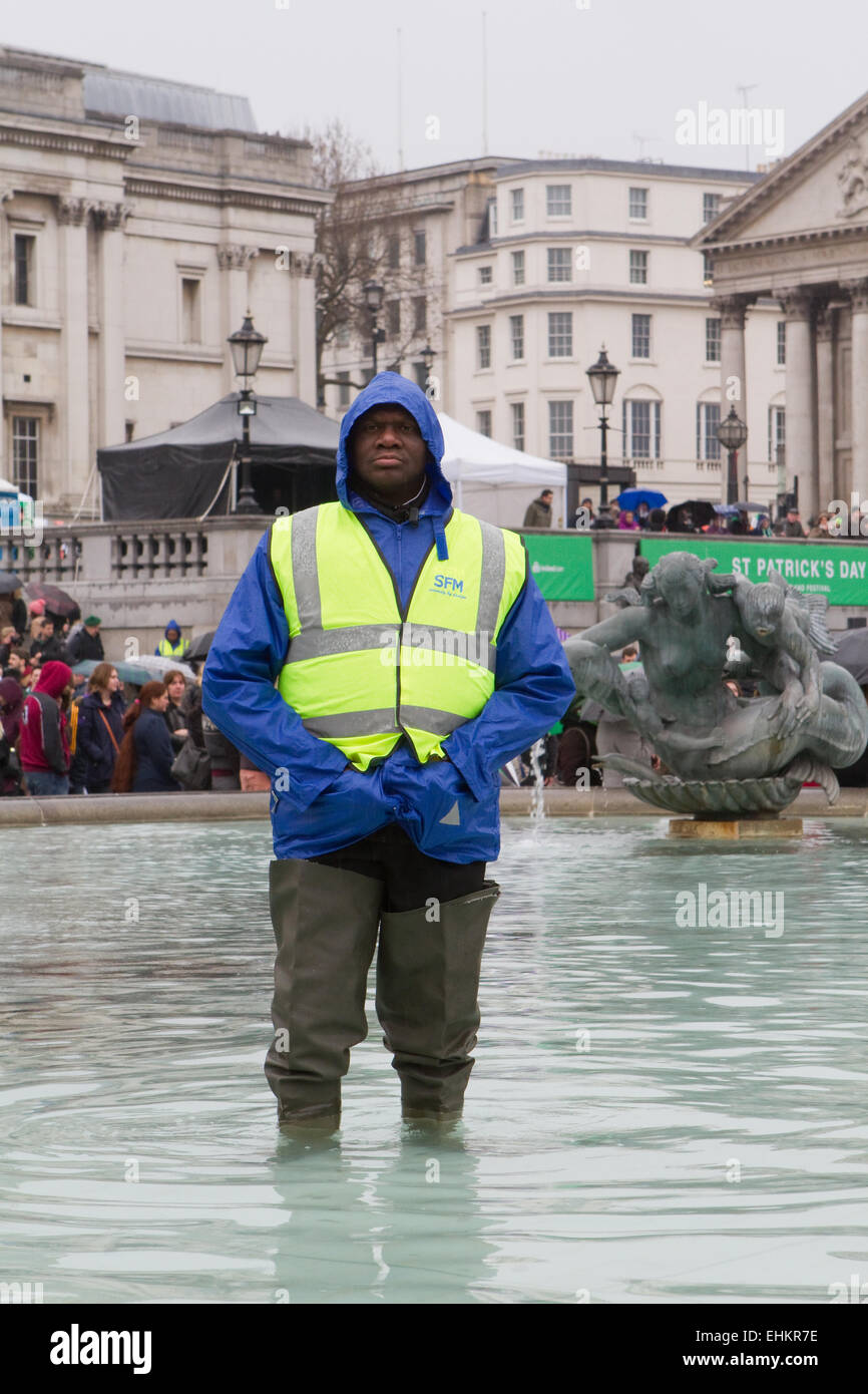 A security guard stands in the water fountain in Trafalgar Square ...