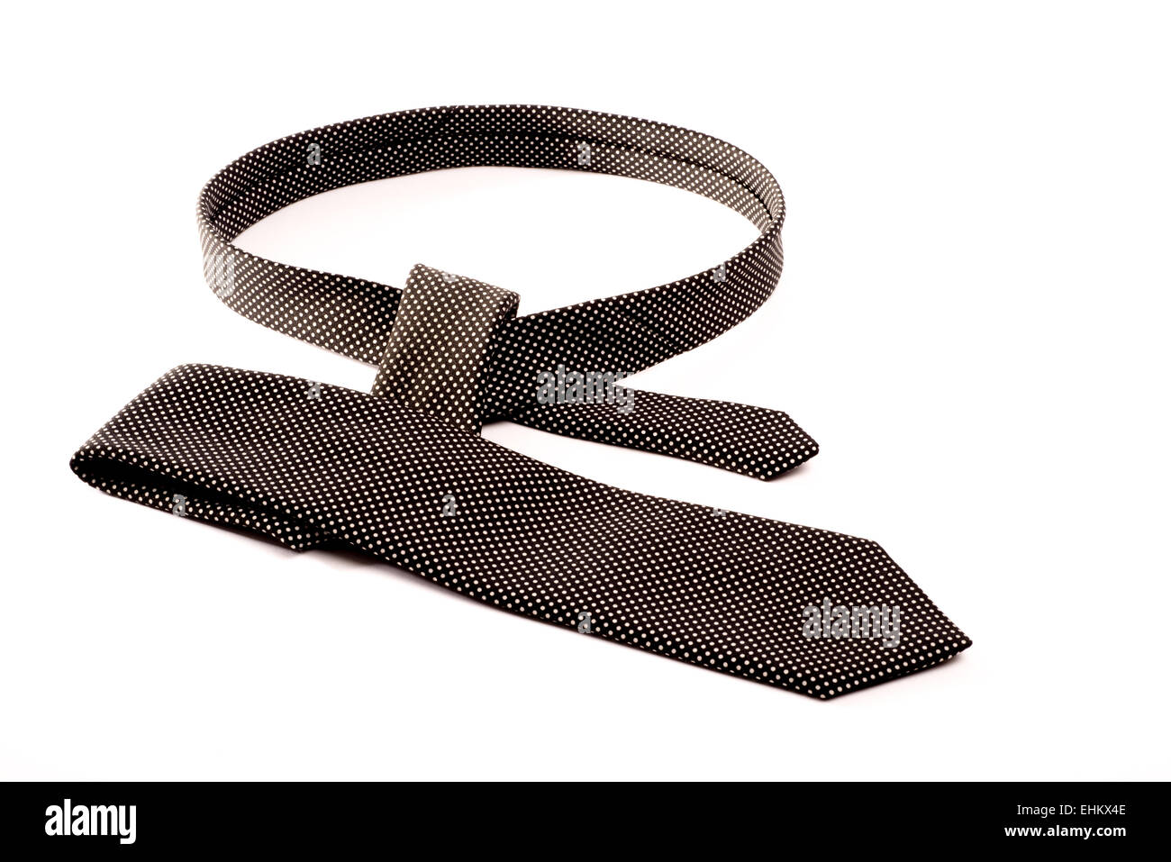 A black and white tie on a white isolated background in the process of ...
