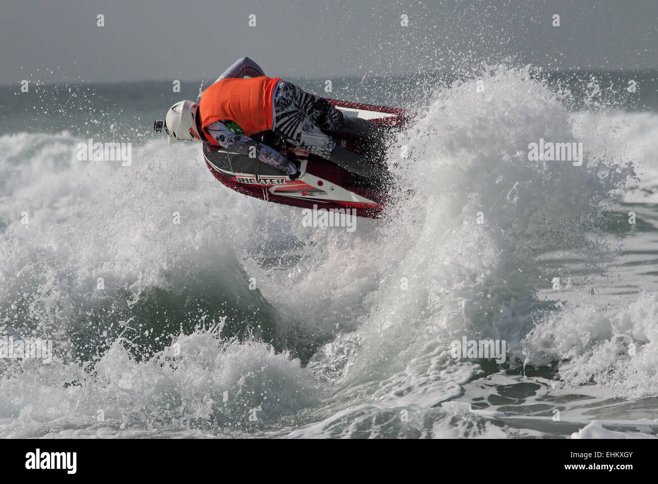 Male jet ski competitor performs aerial action moves in large breaking ...