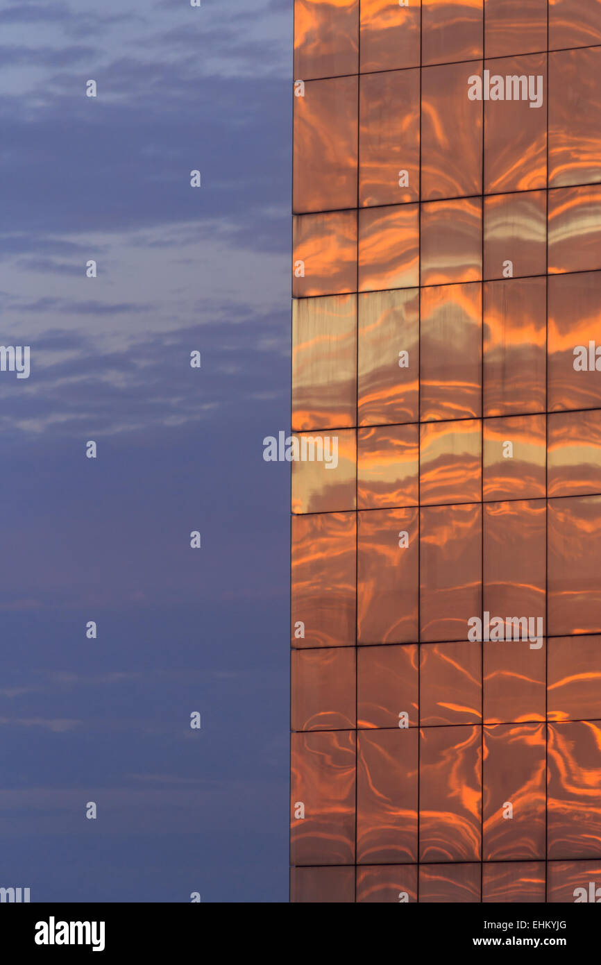Glass building reflecting sky colors and blue sky Stock Photo - Alamy