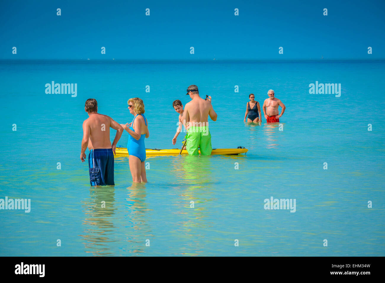 Father oversees son's attempt at paddle boarding in the shallow and ...