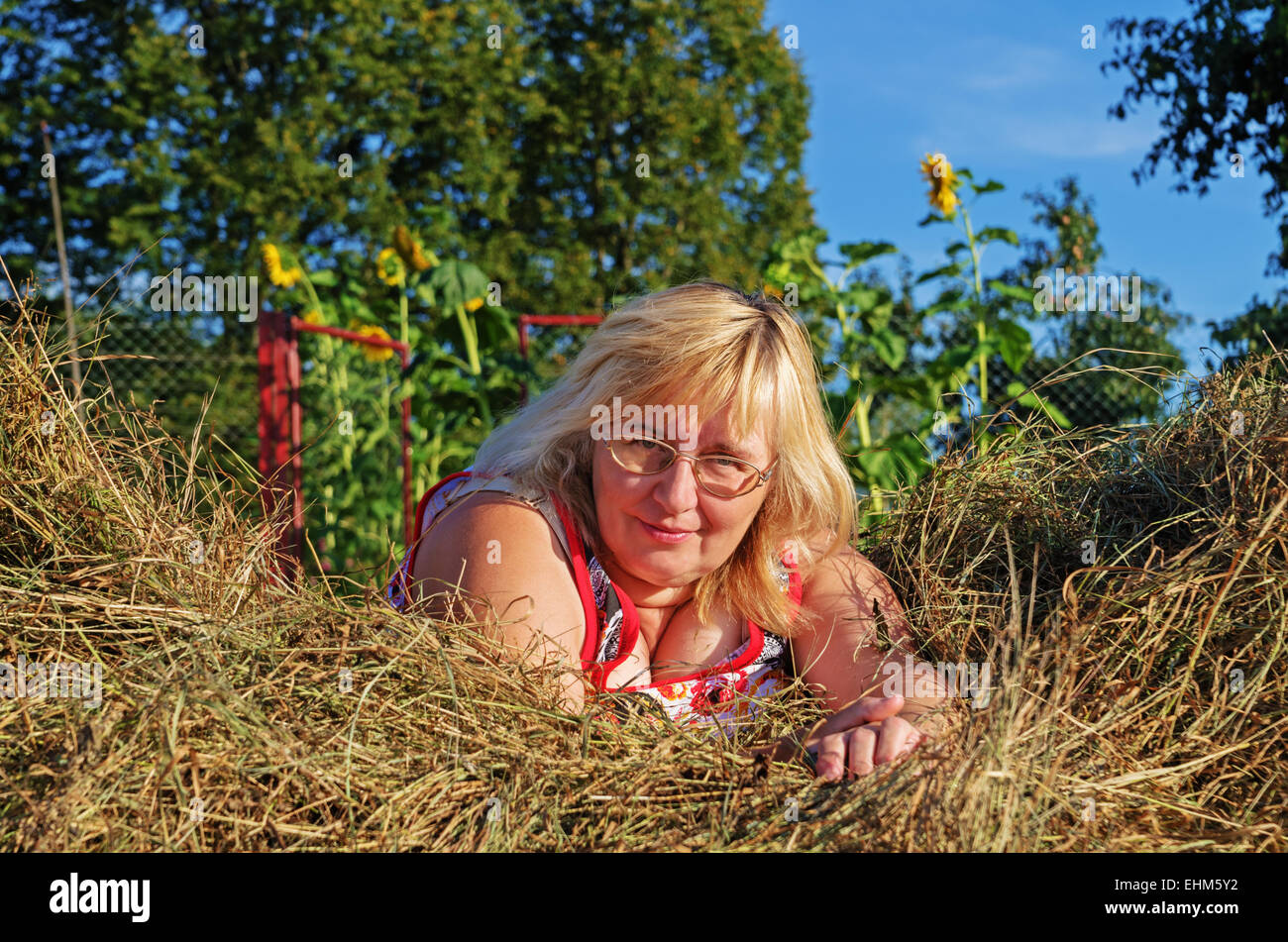 The happy woman gathering a hay pile in the village Stock Photo - Alamy