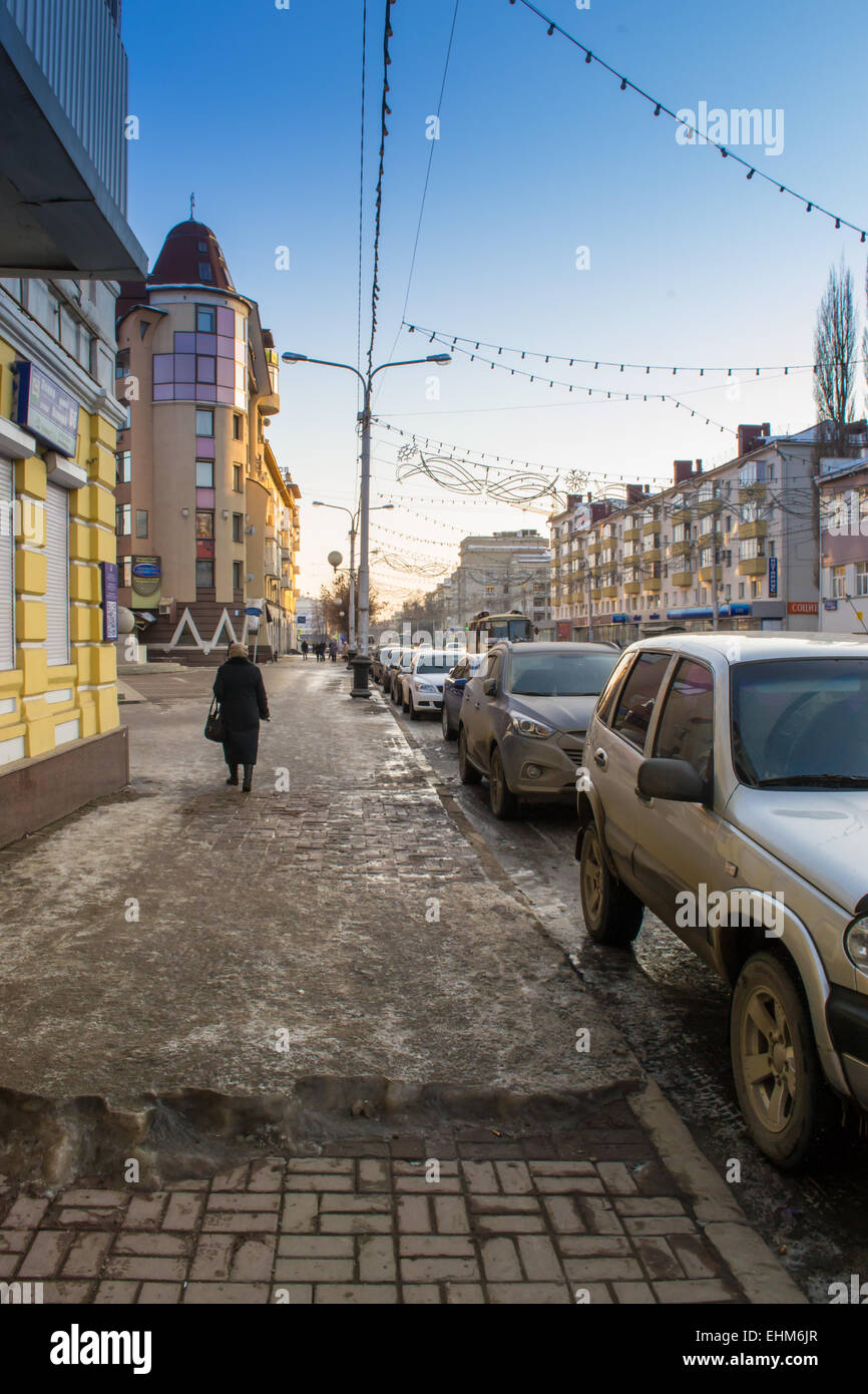 A quite urban winter street scene with melting snow, ice and slush ...