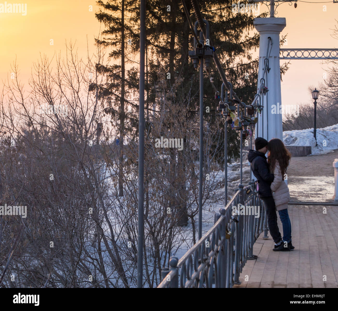 Two people embrace on the bridge of love as sunset begins Stock Photo ...