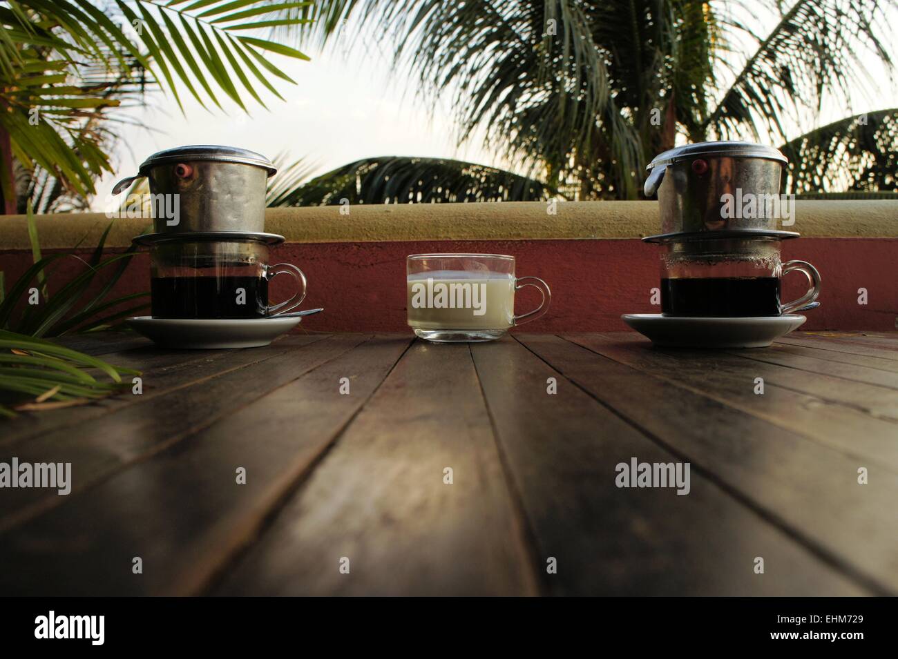 Vietnam Dripping Coffee with milk under palm trees Stock Photo - Alamy