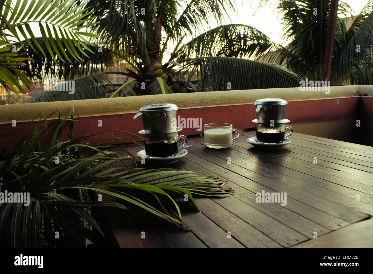 Vietnam Dripping Coffee with milk under palm trees Stock Photo - Alamy