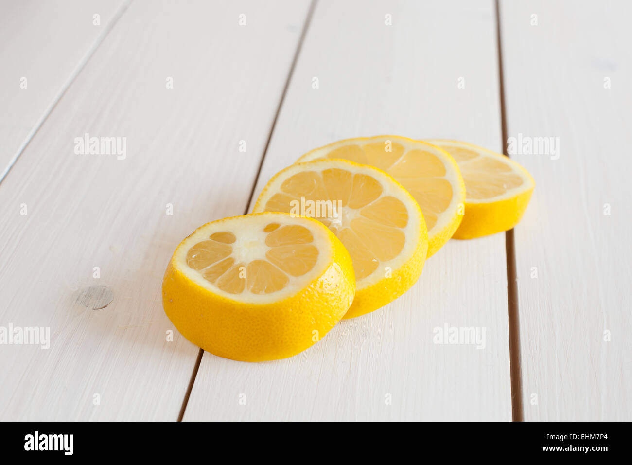 sliced lemon on white wood Stock Photo - Alamy