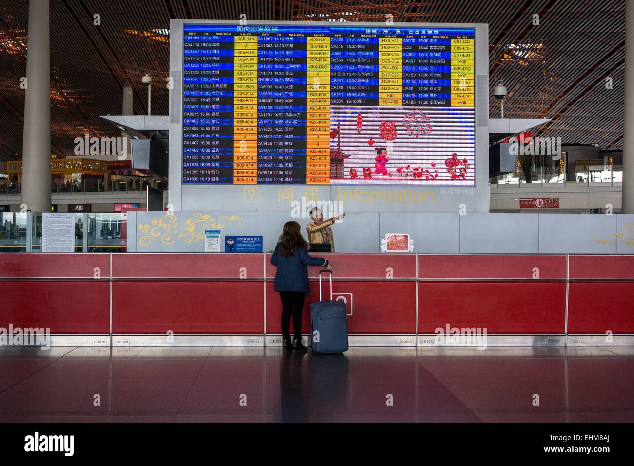 Passenger inquires at info desk in Beijing international airport ...