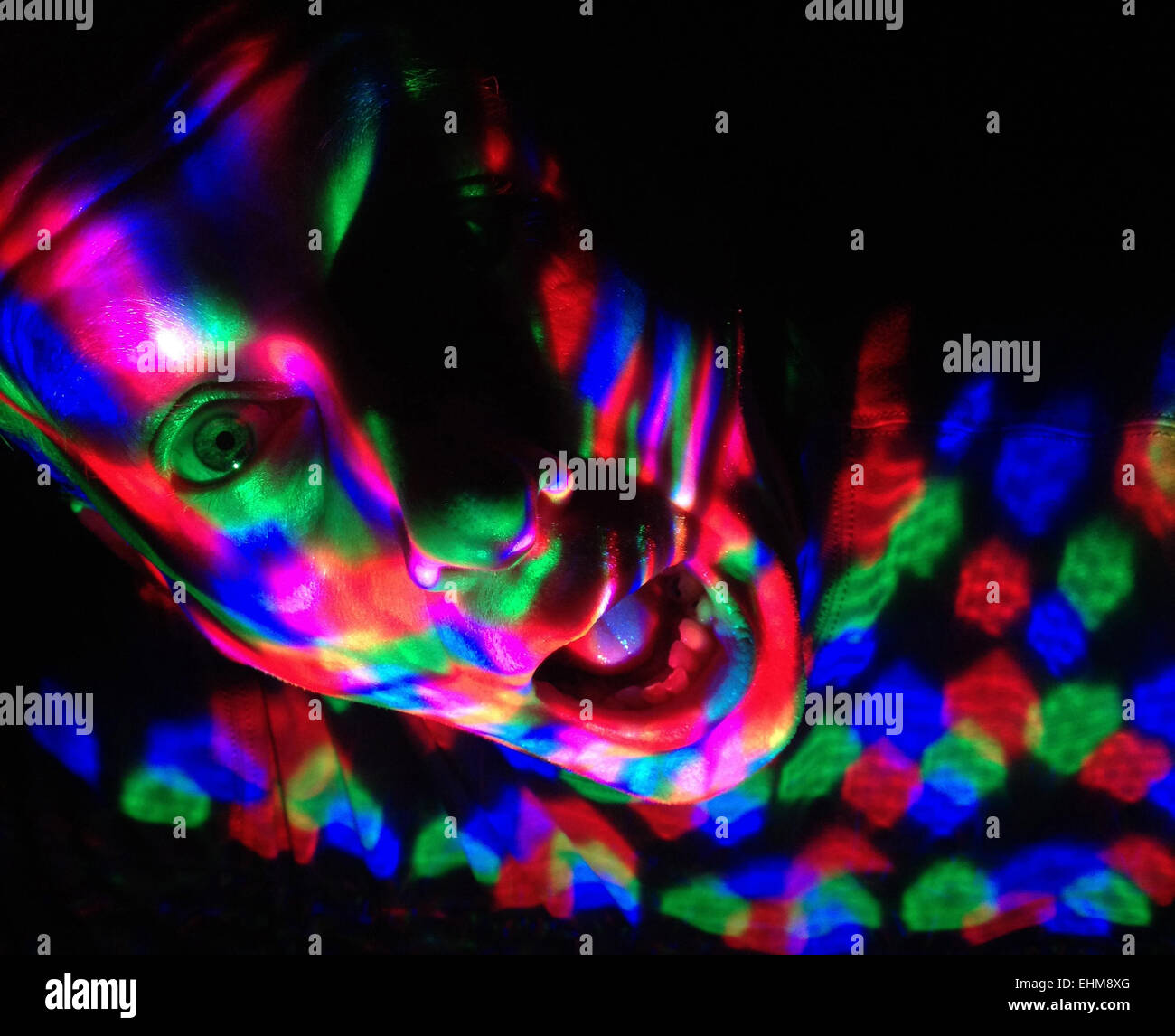 Colorful lights on surprised face of Caucasian man Stock Photo - Alamy