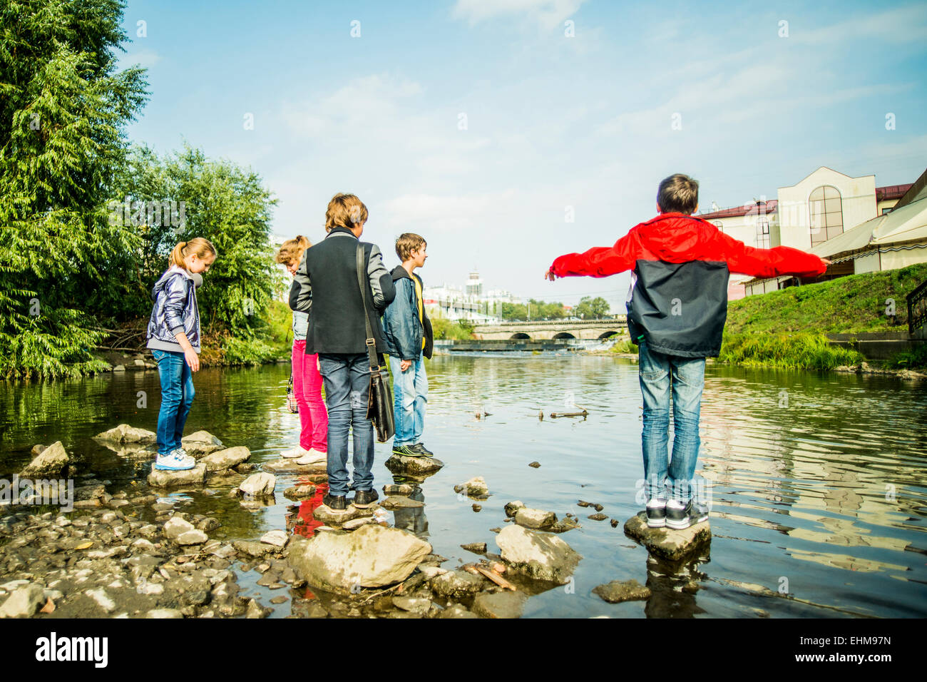 Caucasian children playing on rocks in river Stock Photo - Alamy