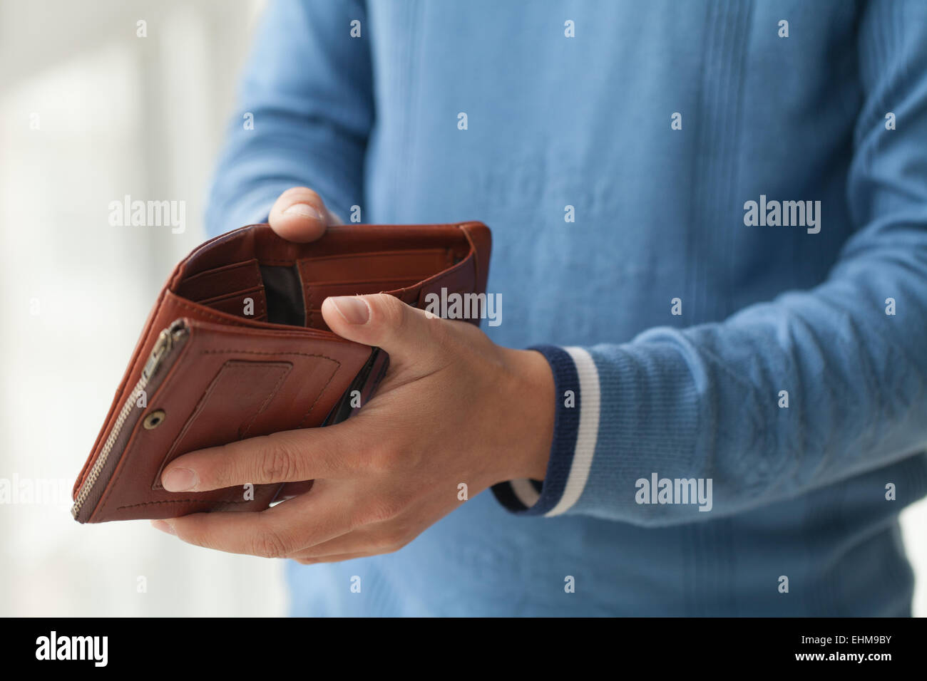 Open brown purse in male hands Stock Photo - Alamy