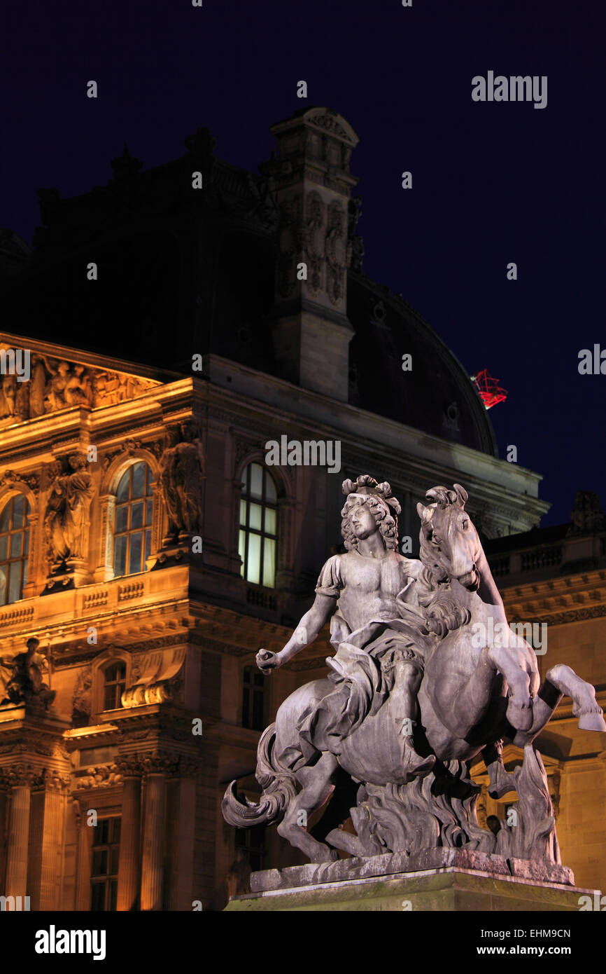 Night view of The Louvre Palace and statue of Louis XIV, Paris, France ...