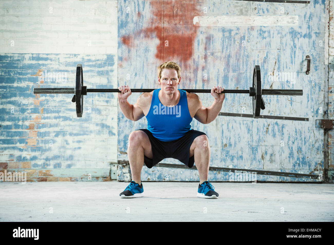 Caucasian man lifting weights in warehouse Stock Photo - Alamy