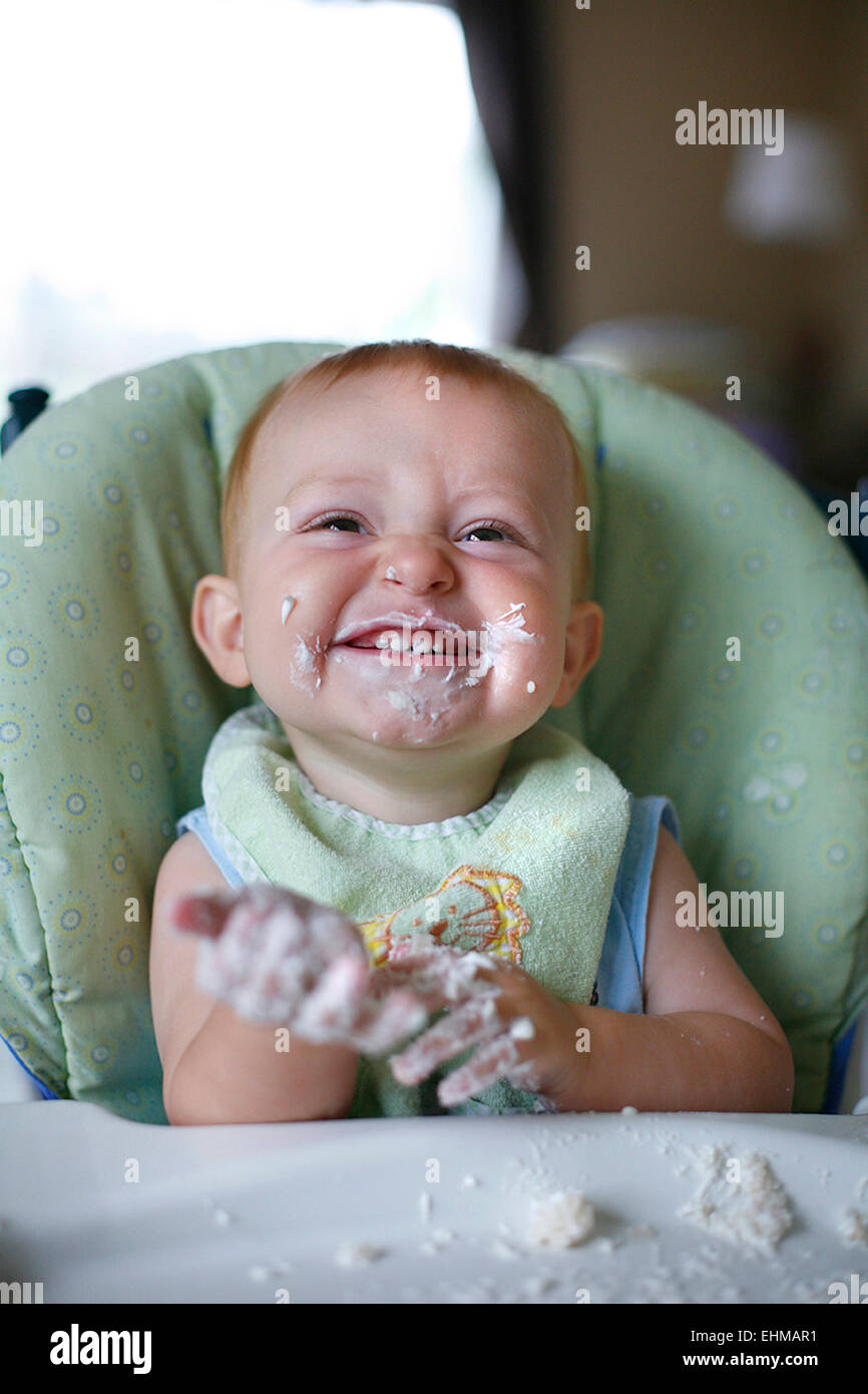 Caucasian baby eating cake in high chair Stock Photo - Alamy