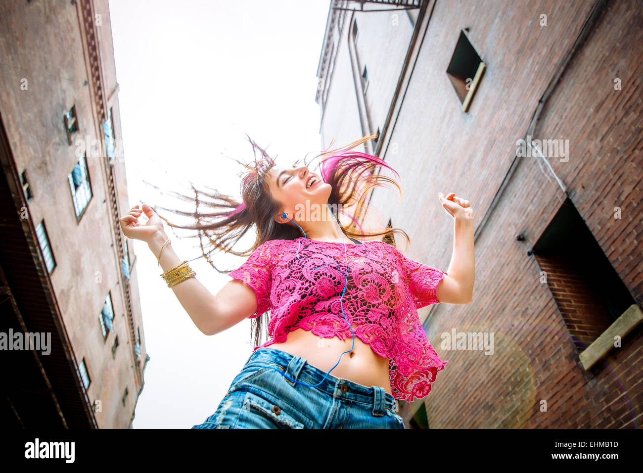 Low angle view of Caucasian woman dancing outdoors Stock Photo - Alamy