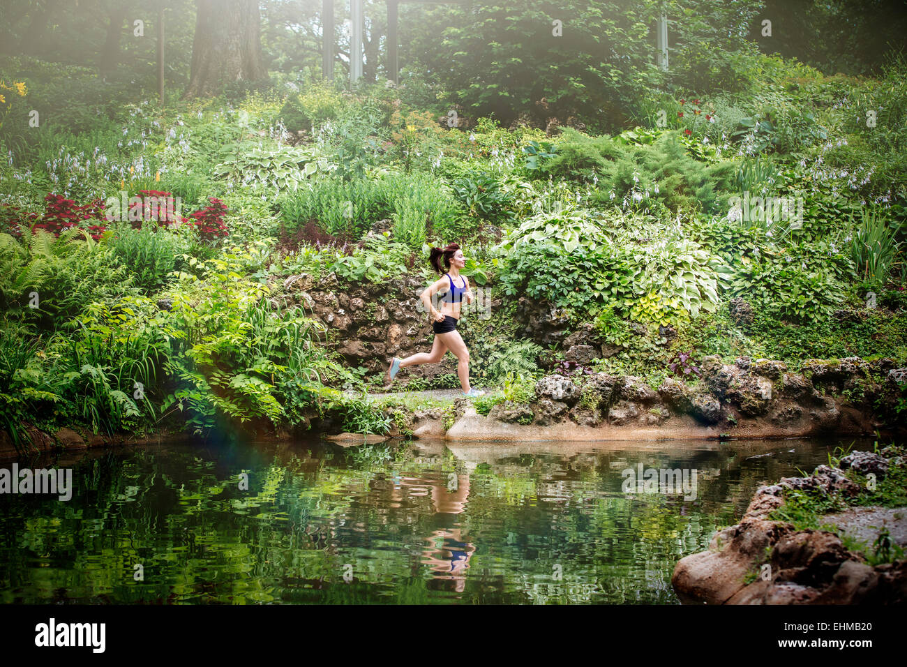 Caucasian woman running near lake in park Stock Photo - Alamy