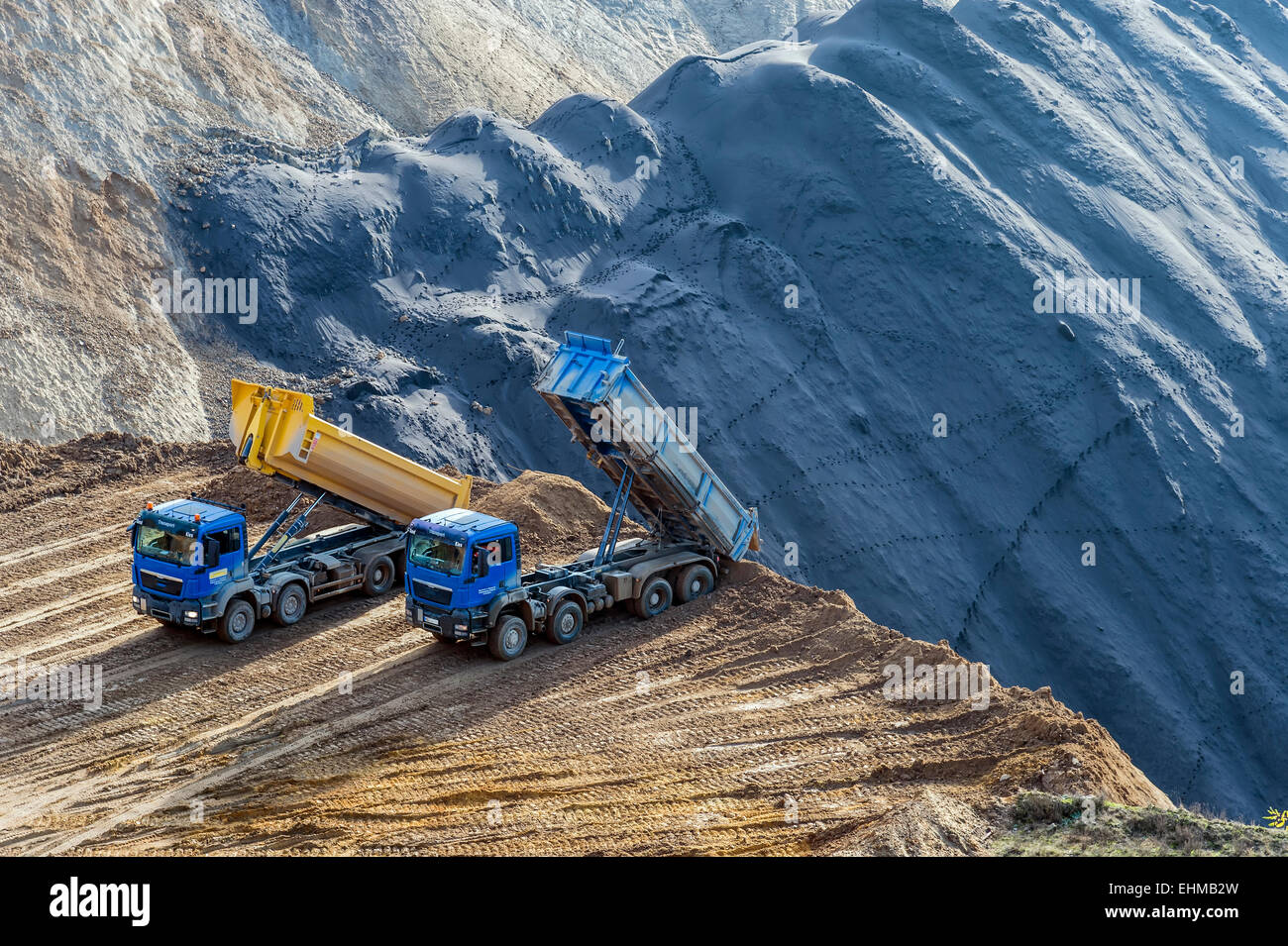 Two tipper trucks standing at the edge of the open cast mine, trying to ...