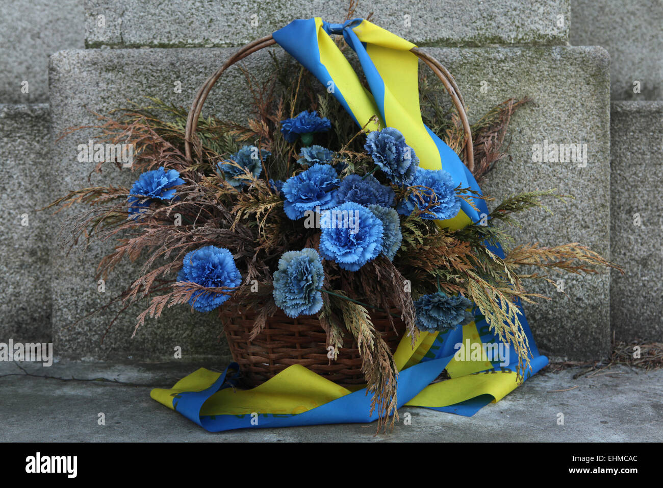 Blue flowers in a basket decorated with Ukrainian national flags at a ...