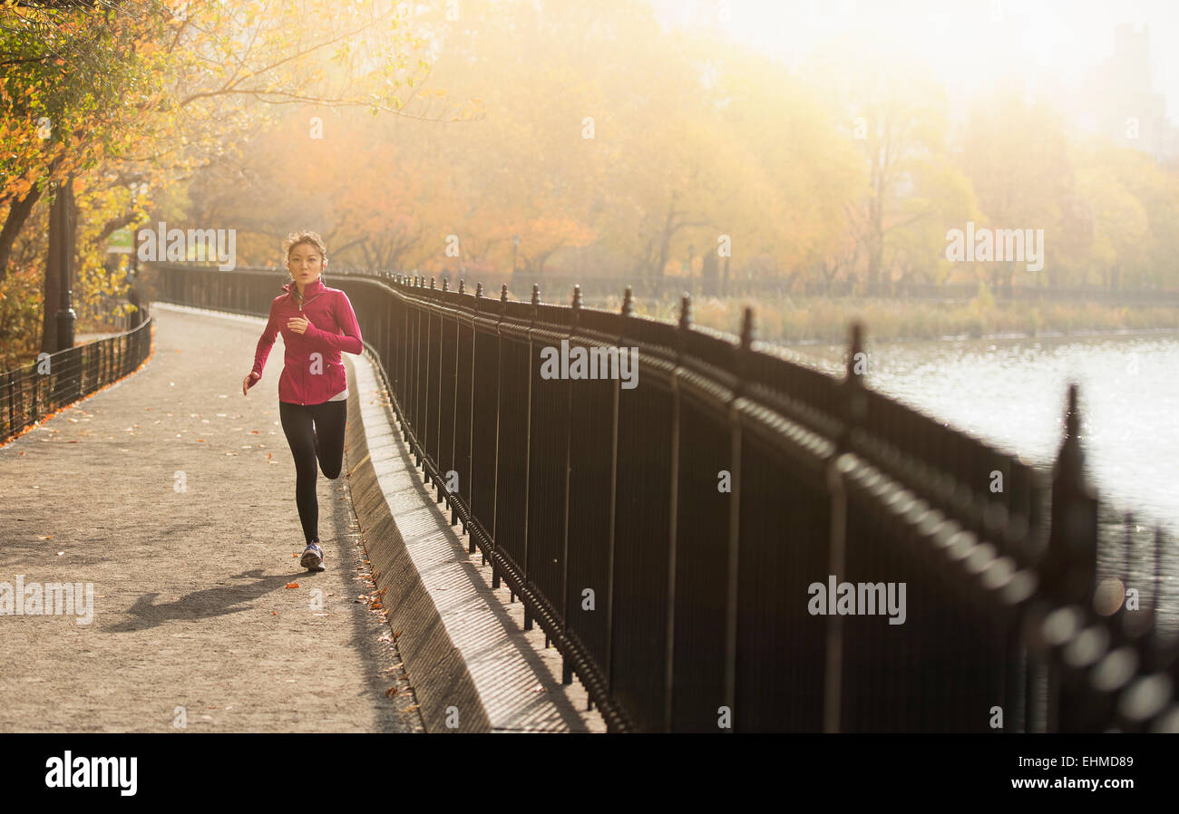 Asian woman running on waterfront path Stock Photo - Alamy