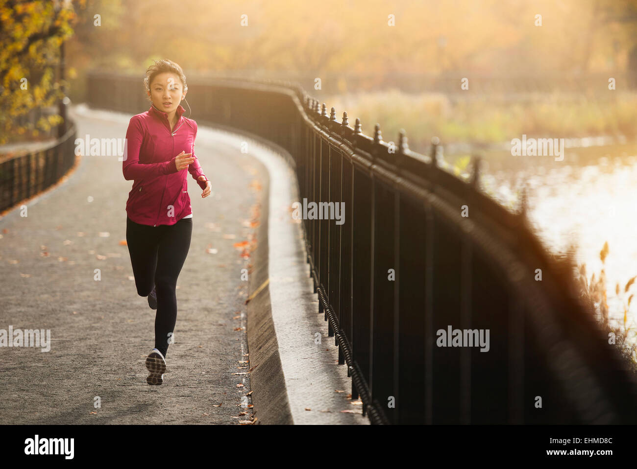 Asian woman running on waterfront path Stock Photo - Alamy
