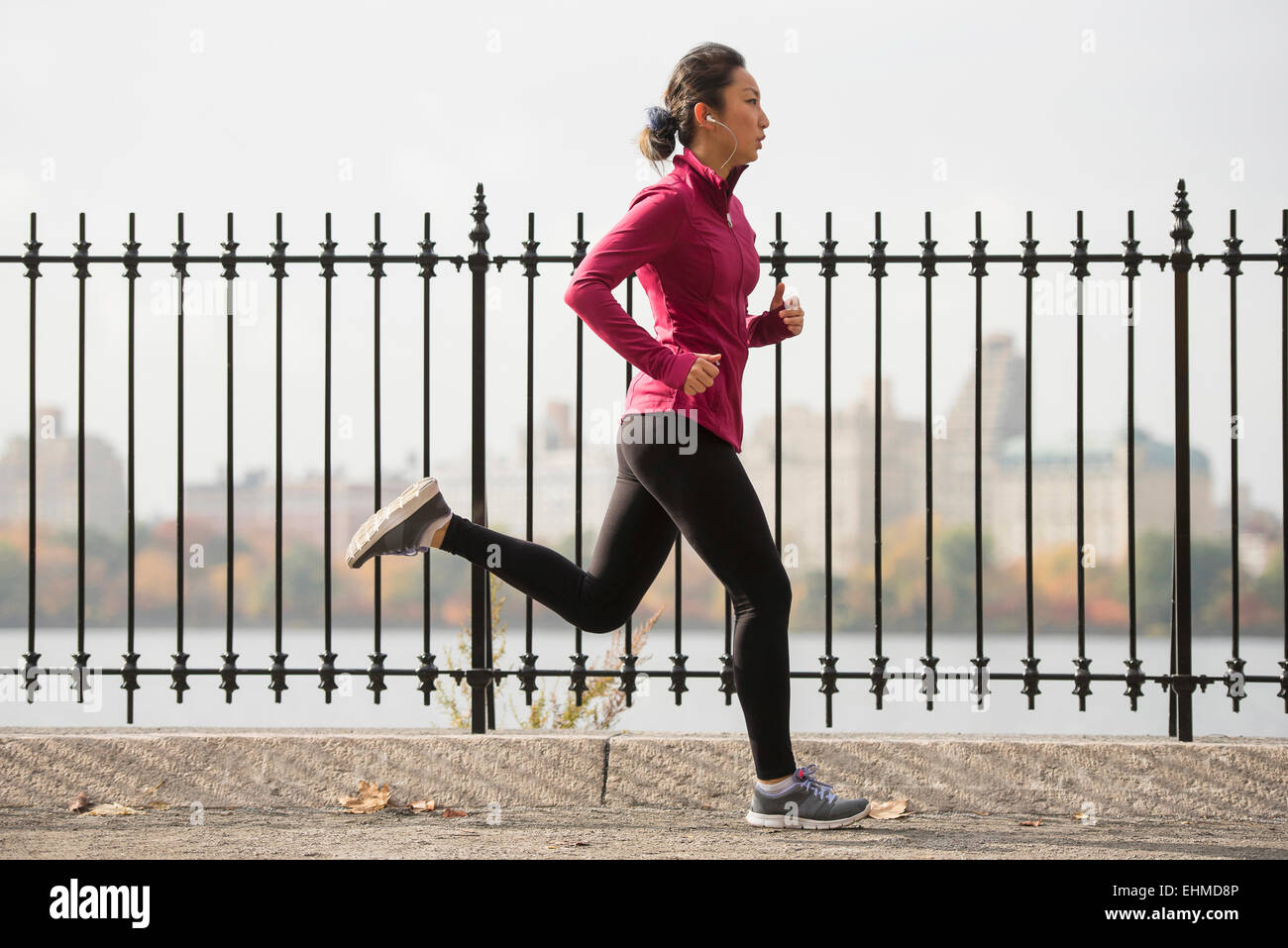 Asian woman running on waterfront path Stock Photo - Alamy