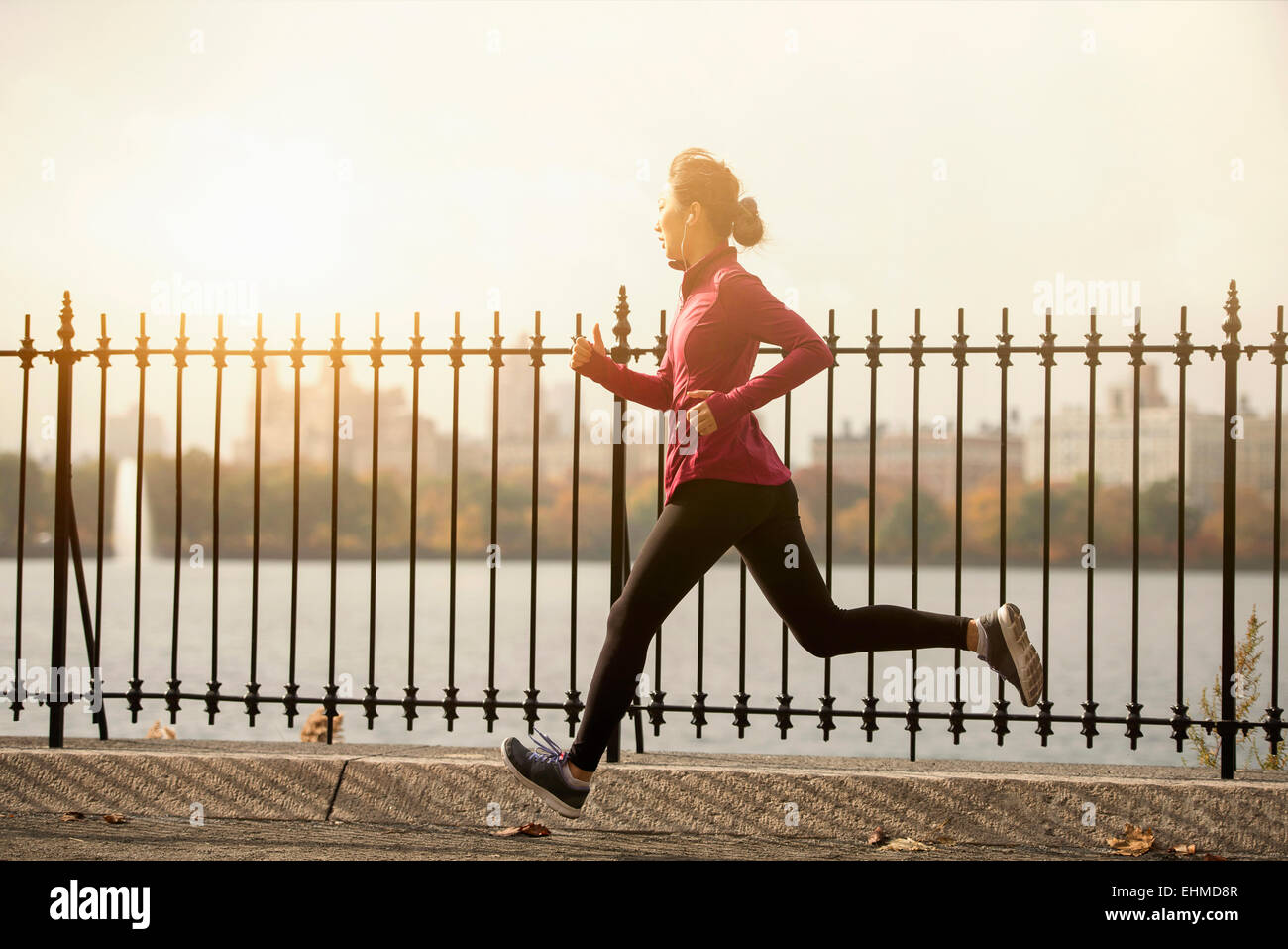 Asian woman running on waterfront path Stock Photo - Alamy