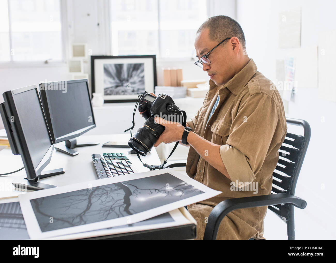 Korean photographer using camera at desk Stock Photo - Alamy