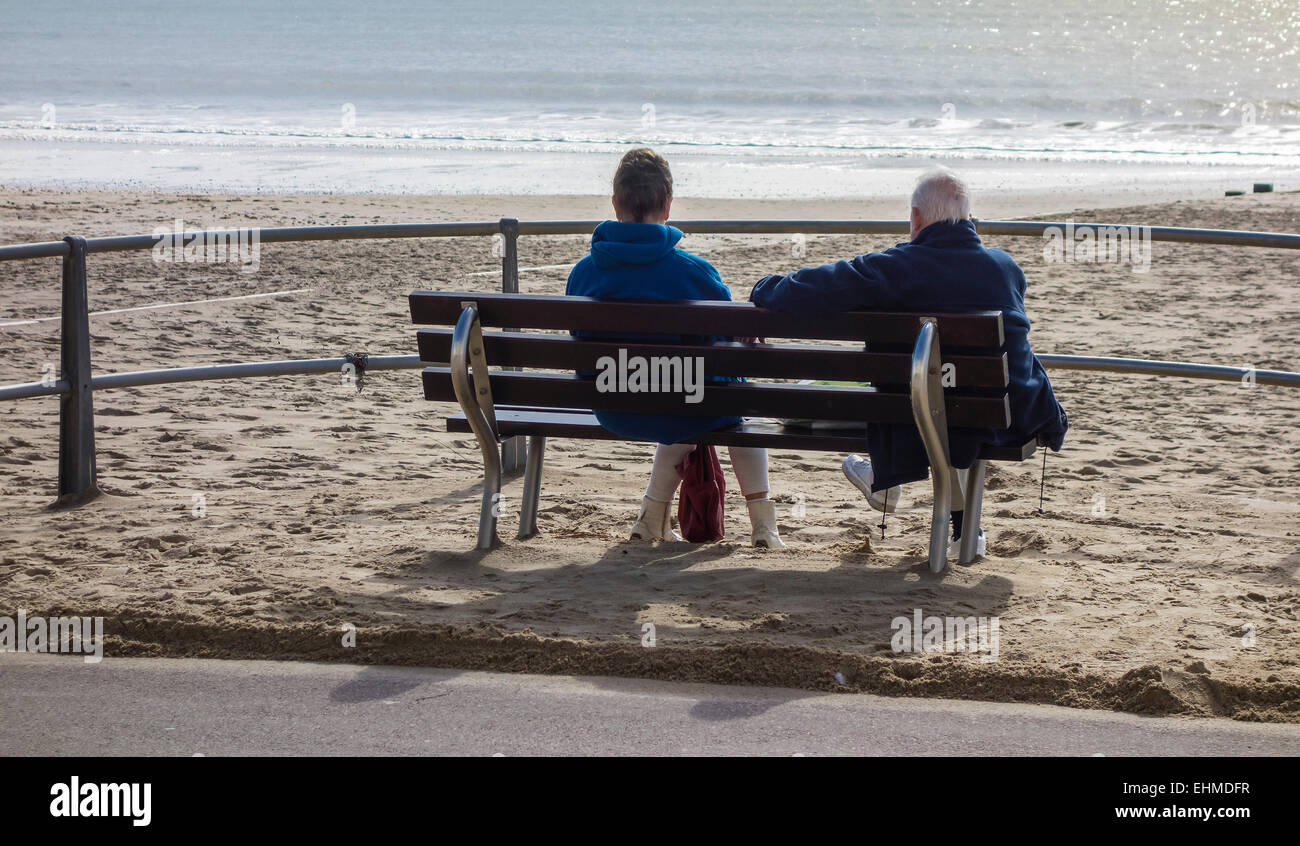 Couple on promenade seat at seaside, Bournemouth, Dorset, England, UK ...