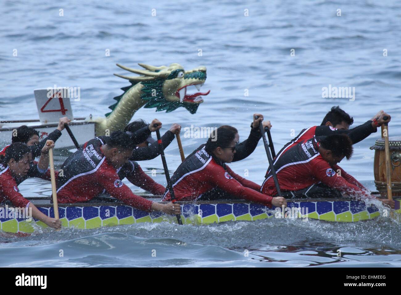 Dragon boat paddlers muscle their way through the waters of Manila Bay ...