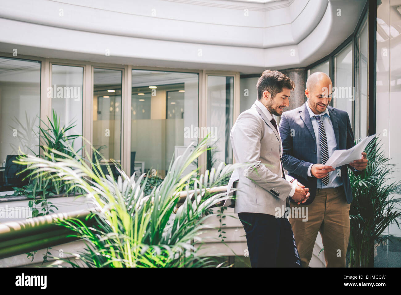 Caucasian businessmen reading paperwork on office balcony Stock Photo ...