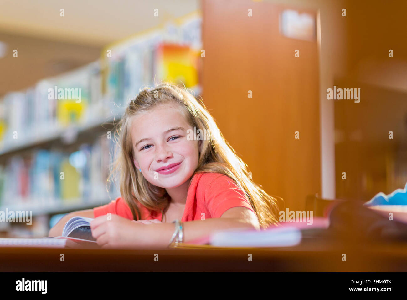 Caucasian student smiling at desk in library Stock Photo - Alamy