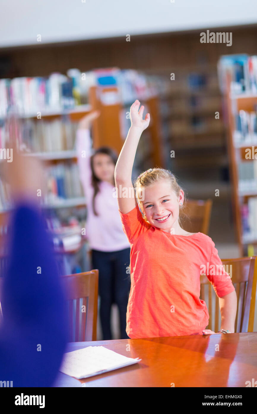 Student raising her hand in library Stock Photo - Alamy