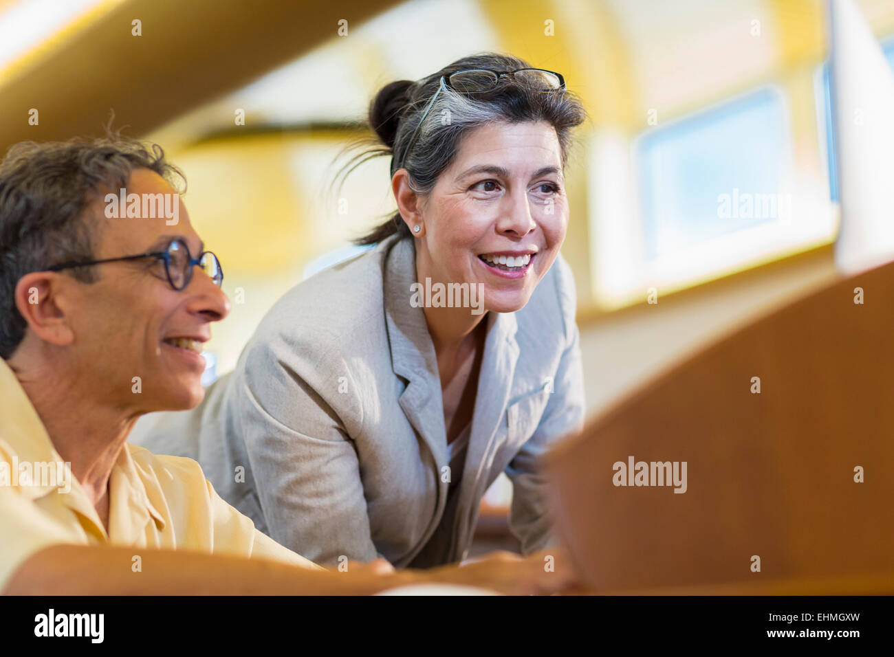 Teacher helping adult student use computer in library Stock Photo - Alamy