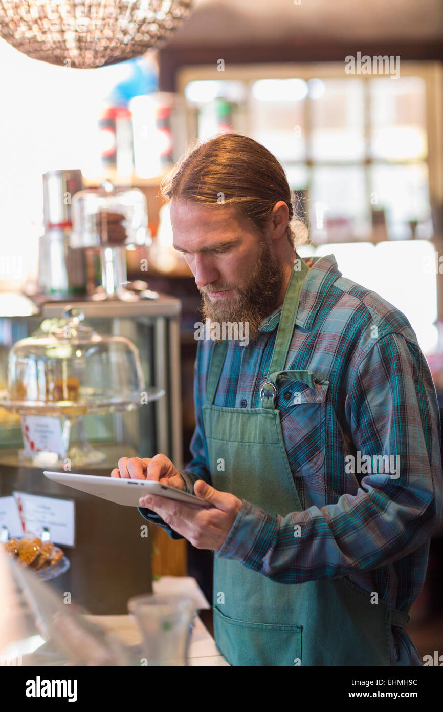 Caucasian server using digital tablet in cafe Stock Photo - Alamy