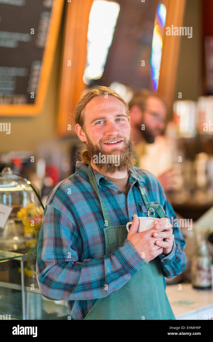 Caucasian server drinking cup of coffee in cafe Stock Photo - Alamy