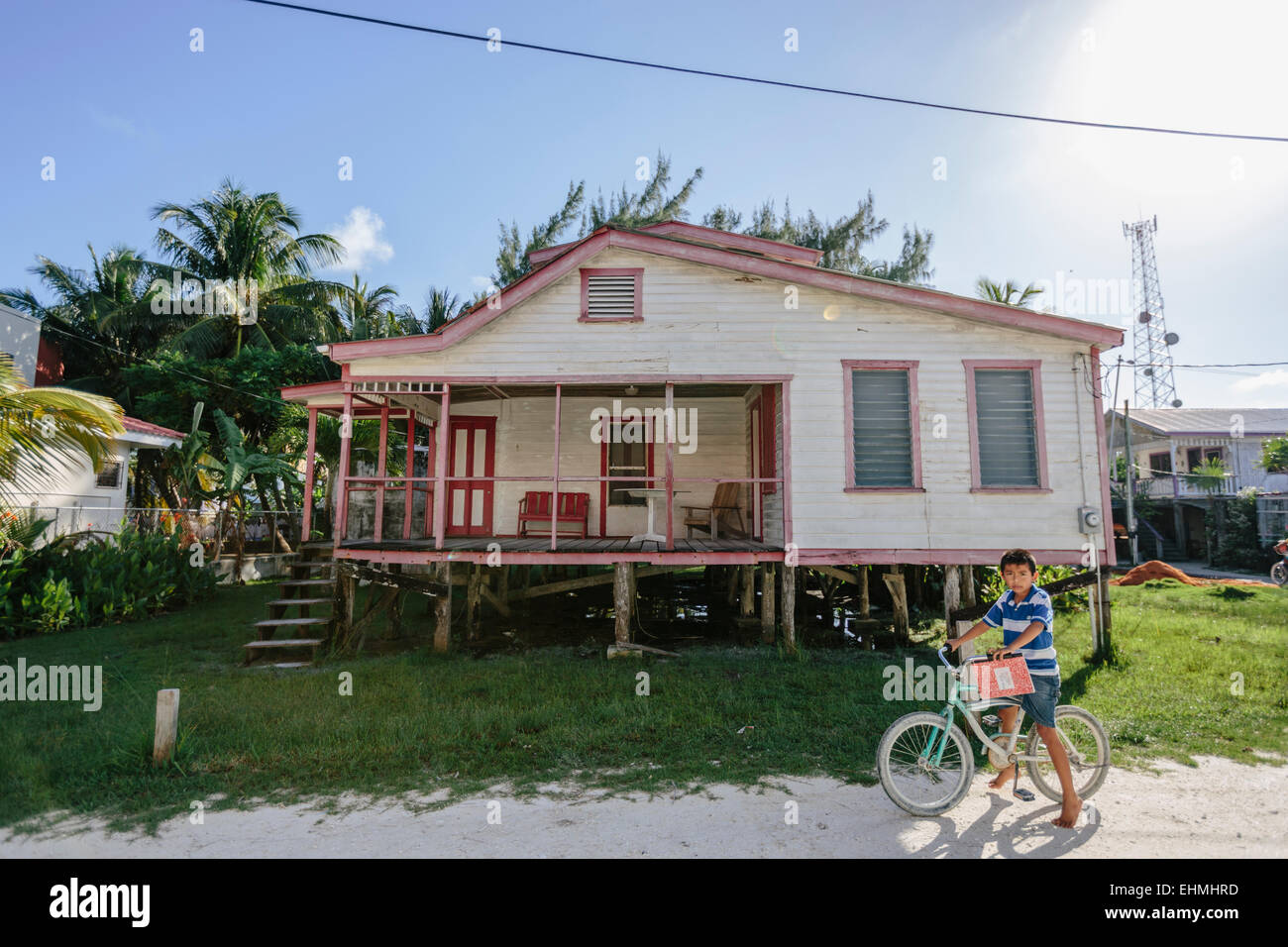 Boy on a bicycle in front of wooden house on Caye Caulker, Belize Stock ...