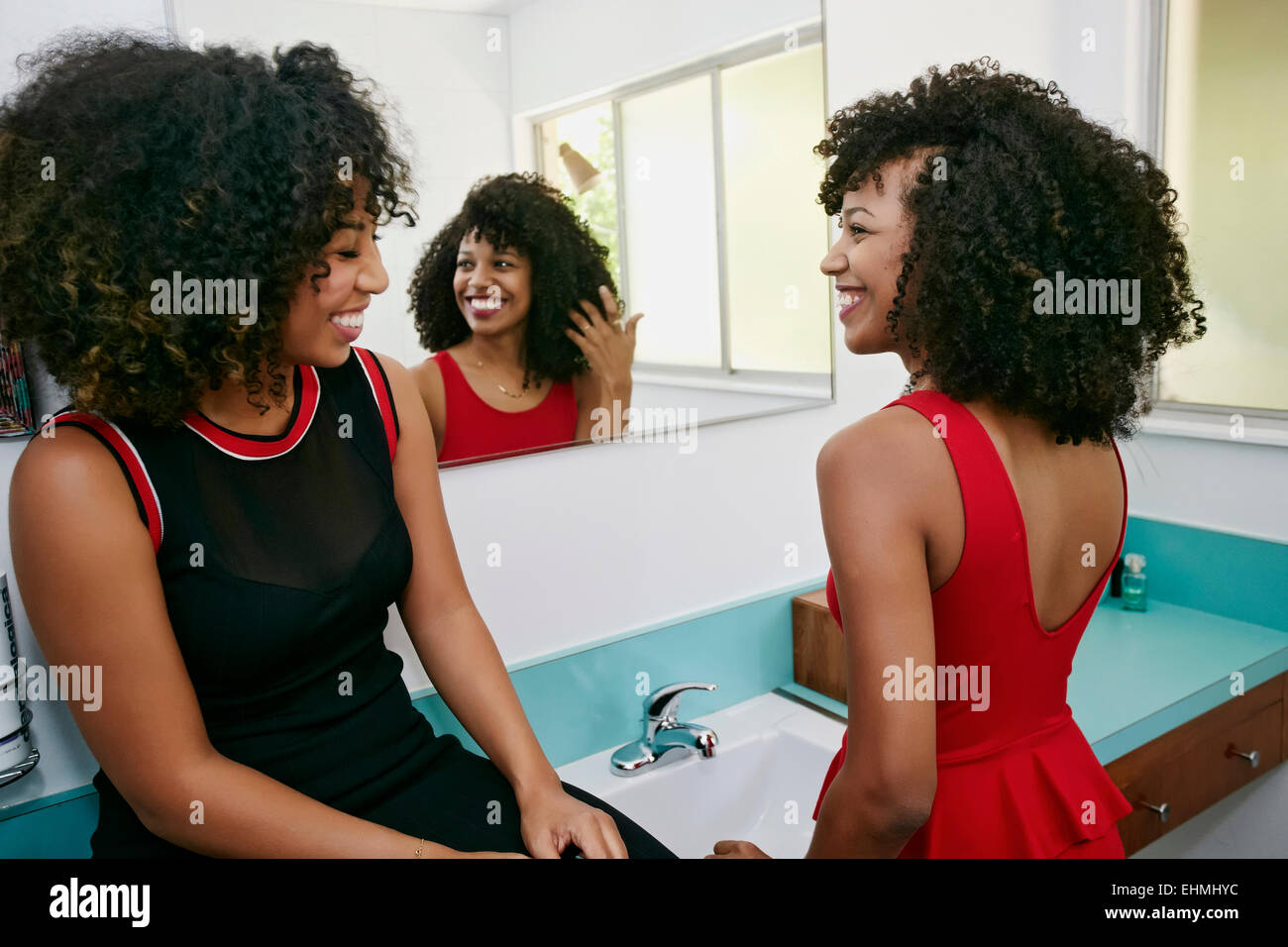 Mixed race women smiling in mirror Stock Photo - Alamy