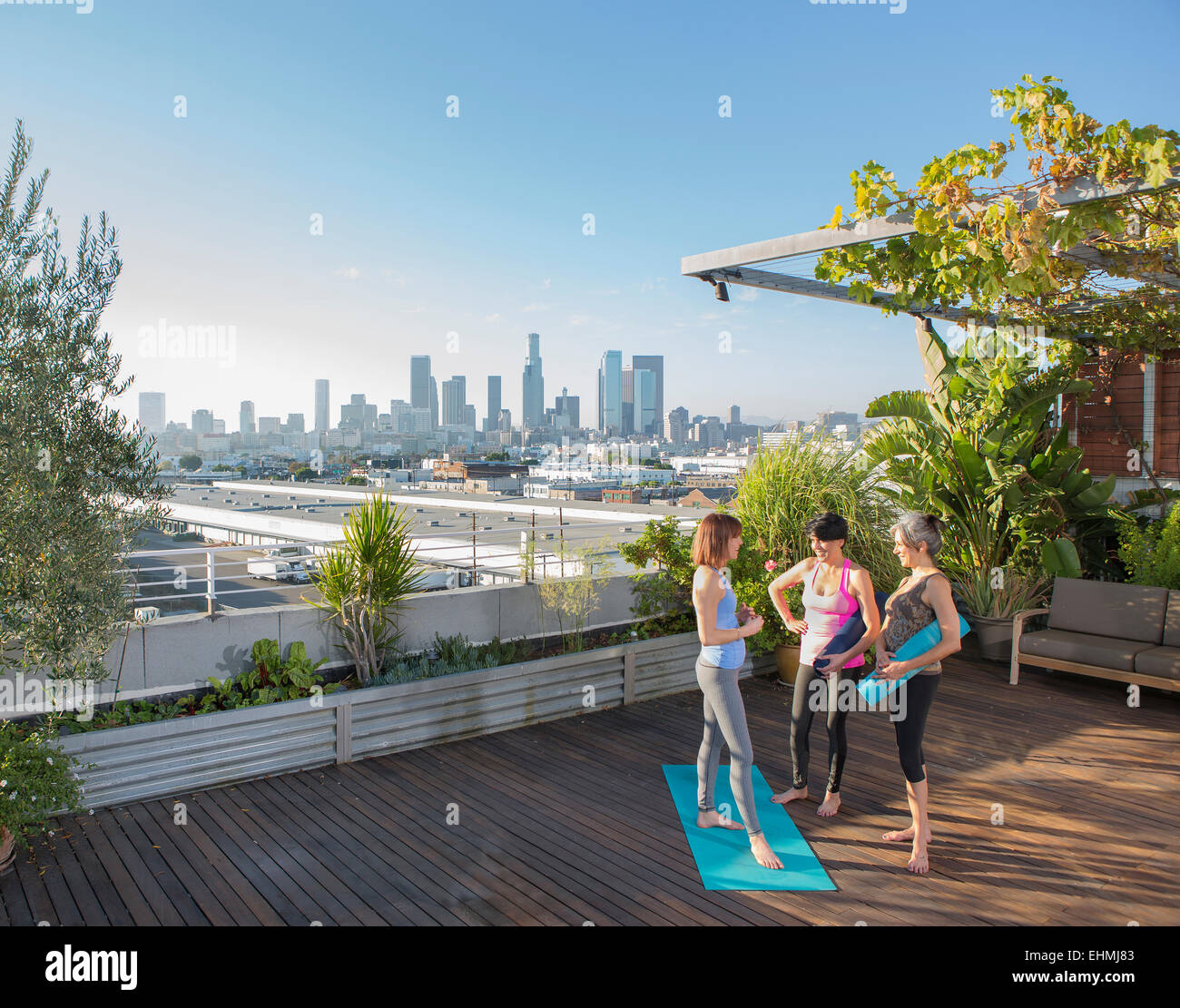 Women talking after practicing yoga on urban rooftop Stock Photo - Alamy