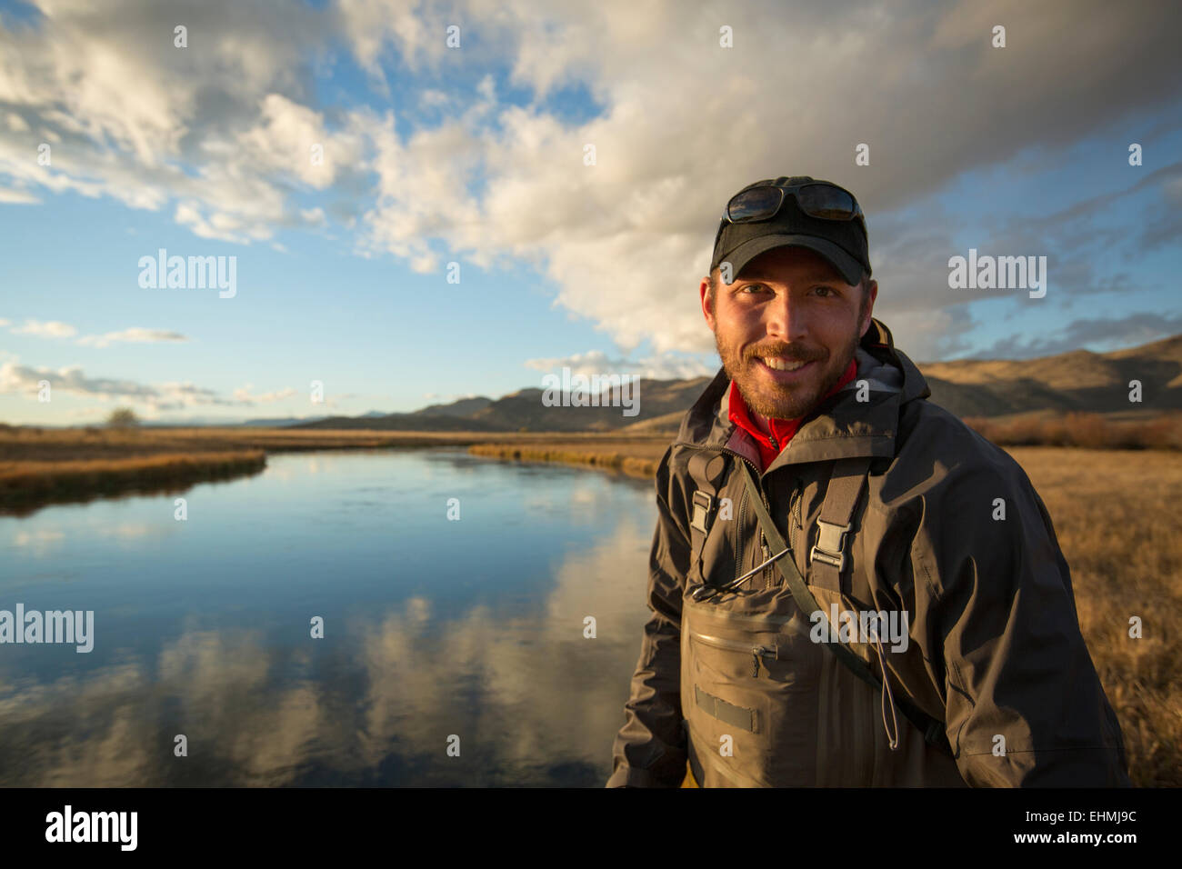Smiling man standing near river Stock Photo - Alamy