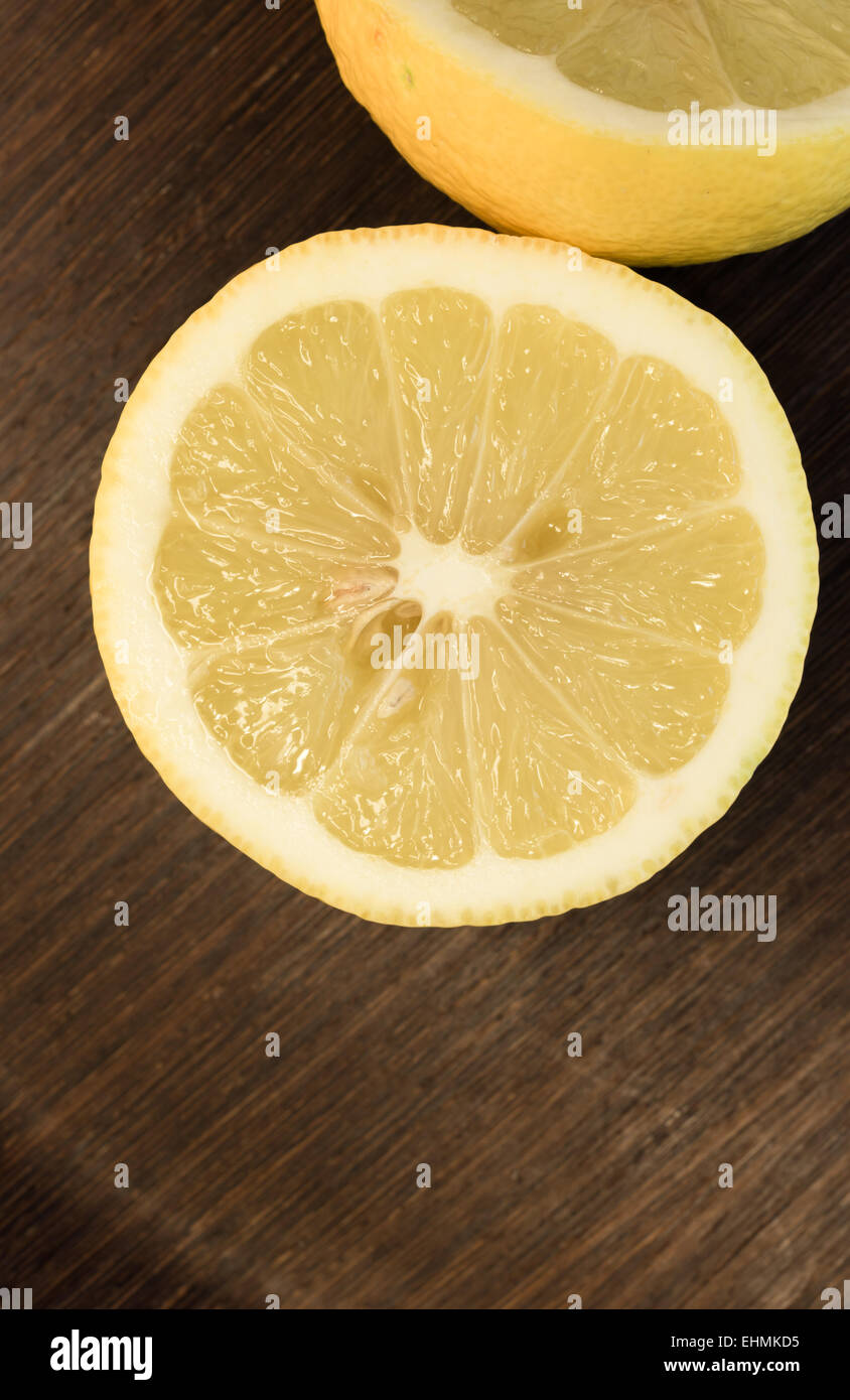 fresh ripe cut lemons on a dark wood background Stock Photo - Alamy