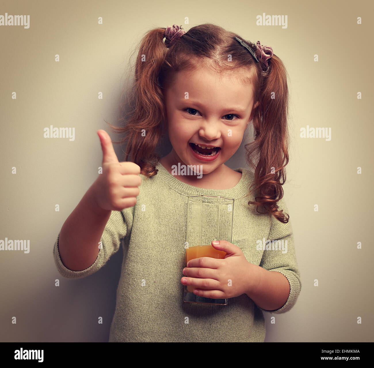 Happy laughing kid girl drinking juice and showing good sign. Vintage ...