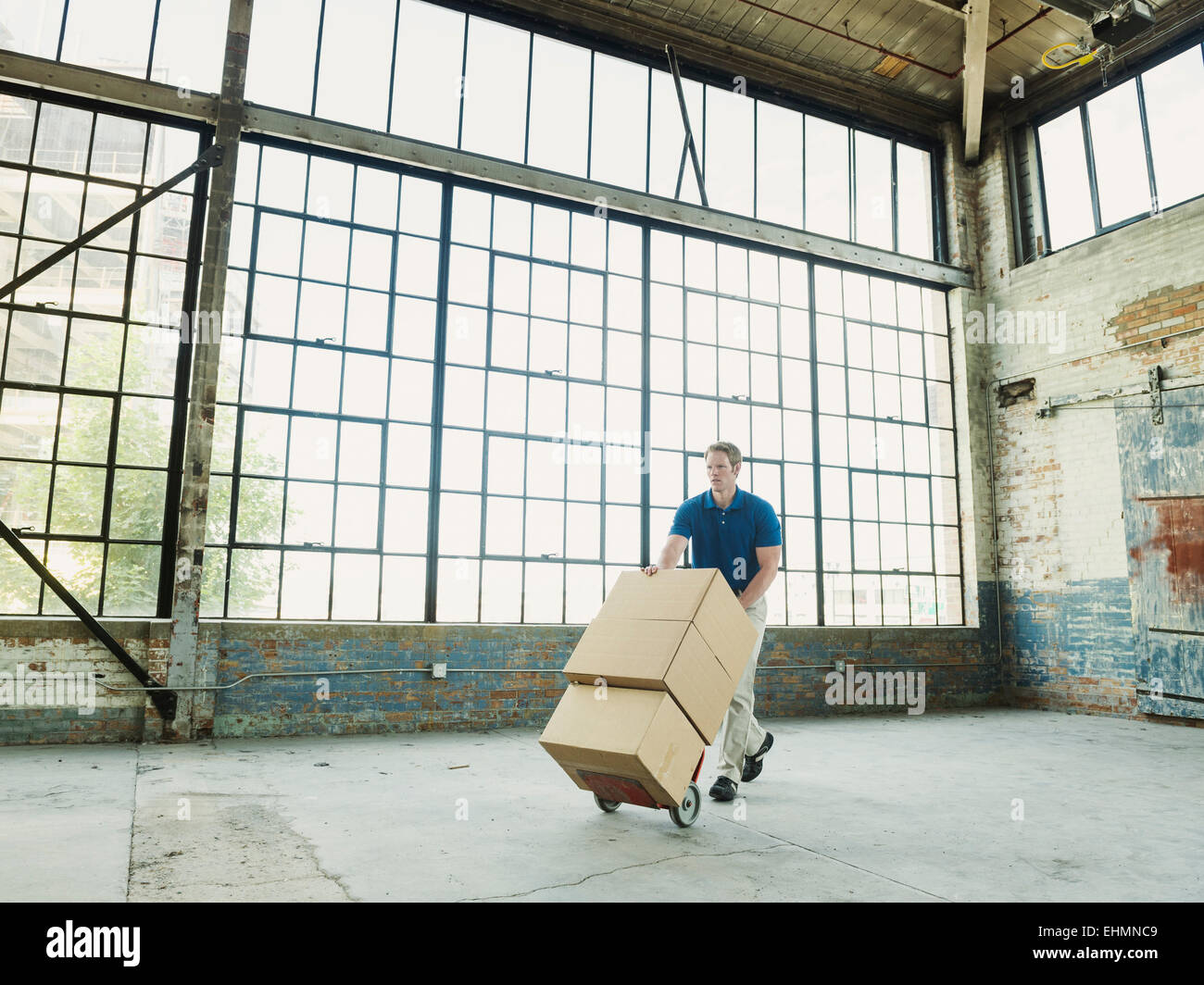 Caucasian businessman pushing cardboard boxes on hand truck in ...