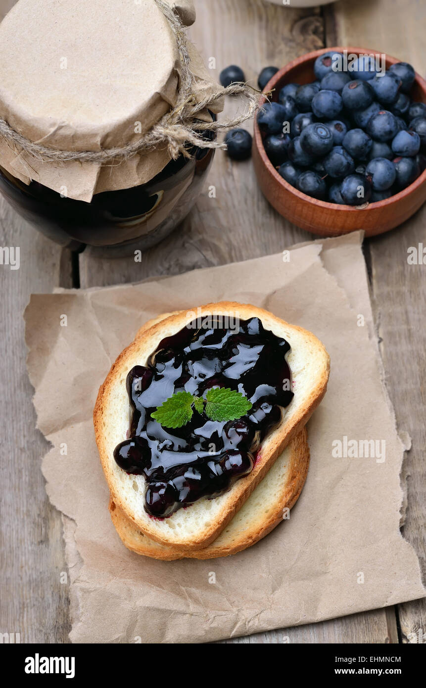Blueberry jam on bread on wooden table, top view Stock Photo - Alamy