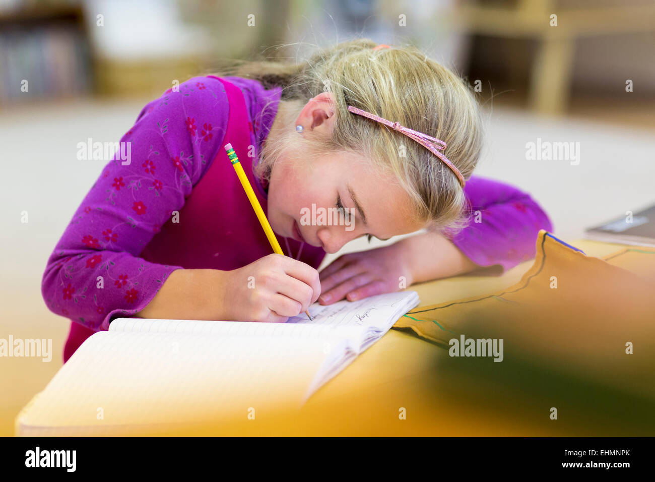 Caucasian girl writing in classroom Stock Photo - Alamy
