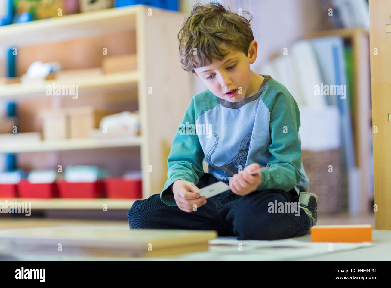 Boy thinking on floor in classroom Stock Photo - Alamy