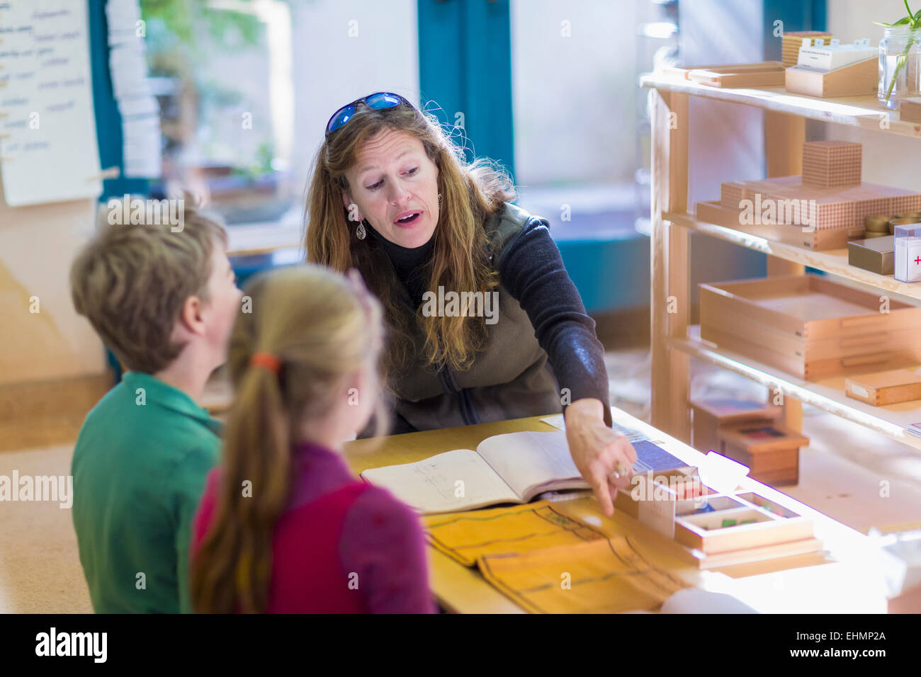 Caucasian Montessori teacher helping students in classroom Stock Photo ...