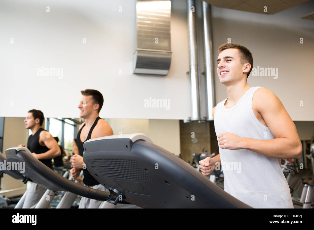 smiling men exercising on treadmill in gym Stock Photo - Alamy