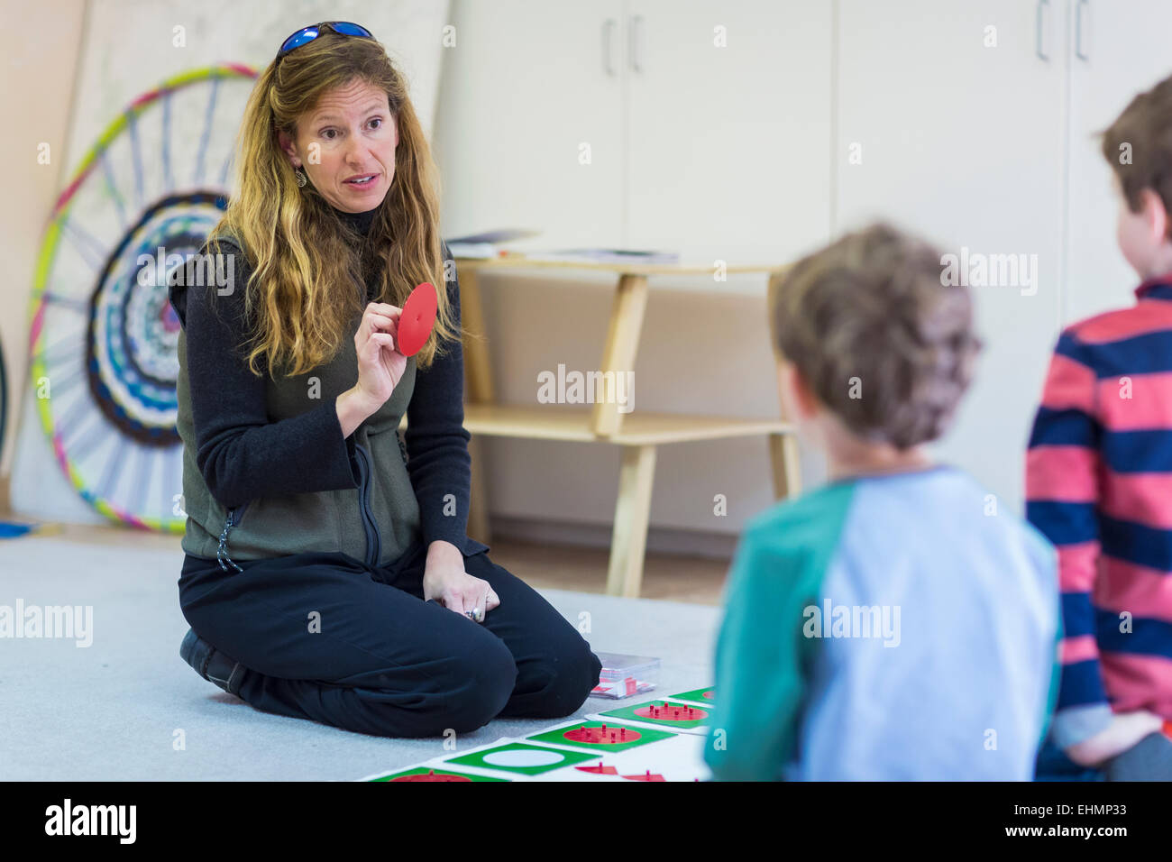 Montessori teacher talking to students in classroom Stock Photo - Alamy